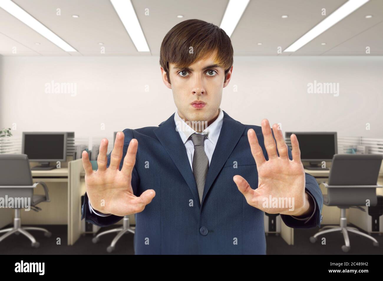 Businessman holding hands up as a stop gesture to tell co-workers to ...