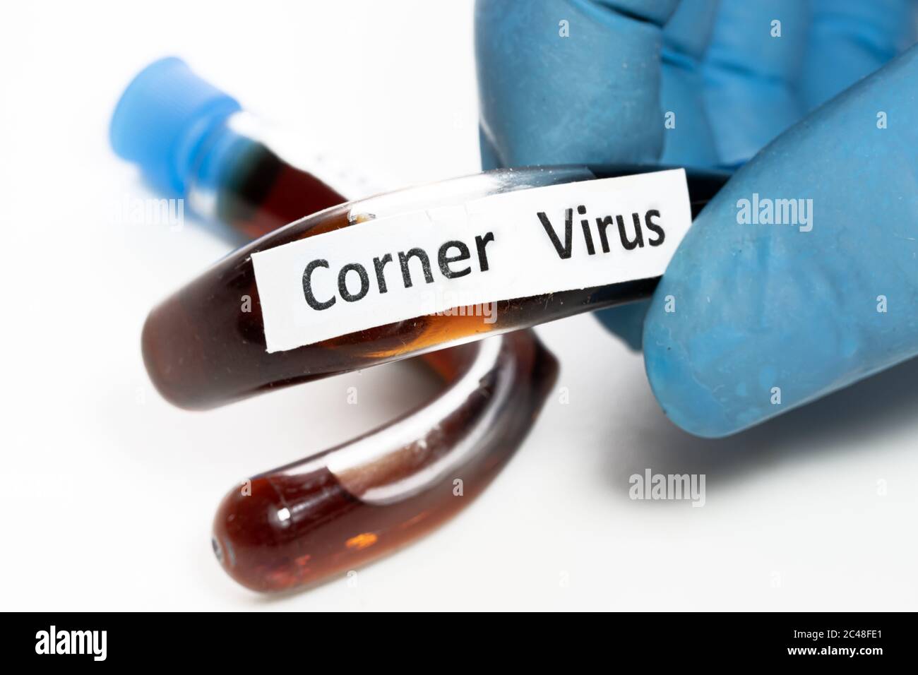 Hand in glove holding a turned test tubes with labels of corner virus ...