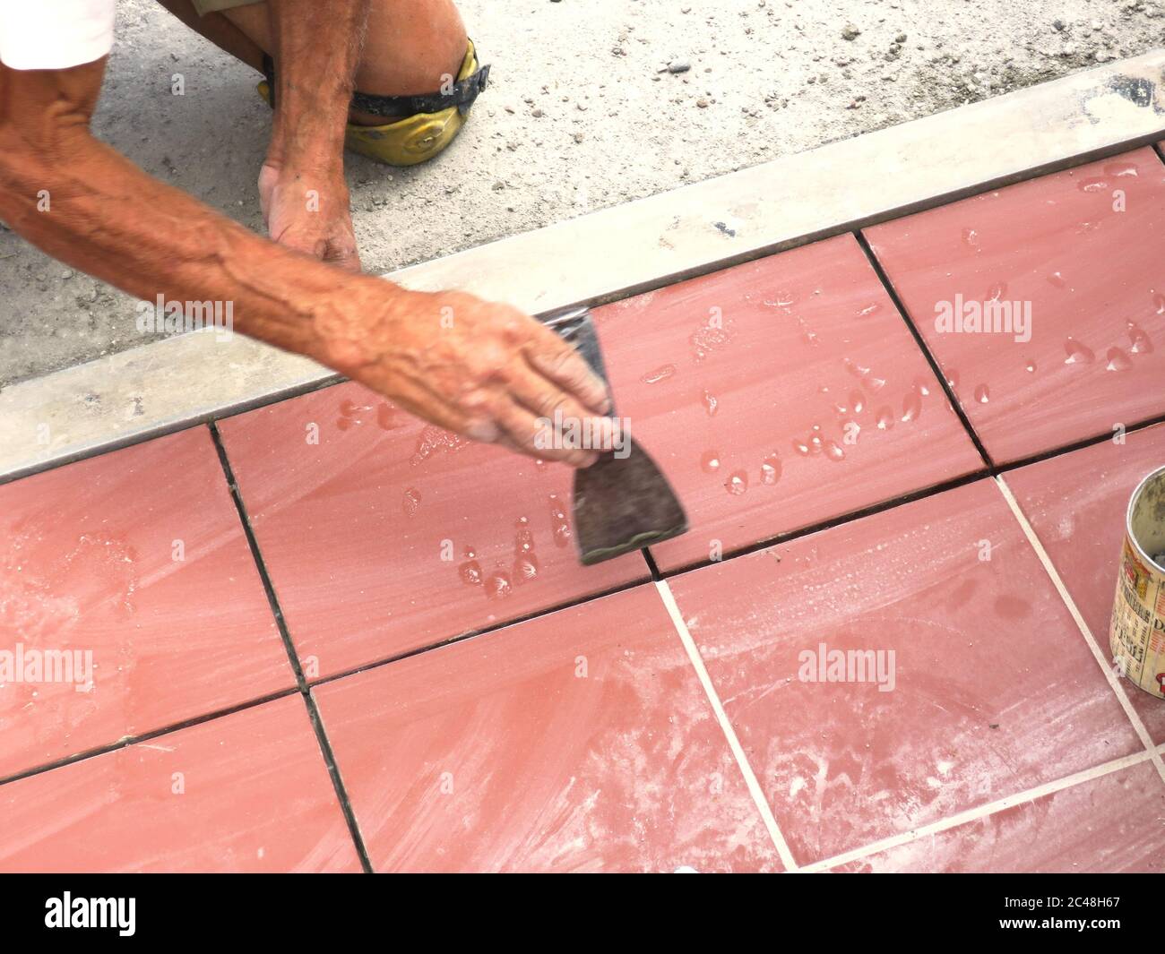 High angle shot of a tiler laying ceramic tiles Stock Photo - Alamy