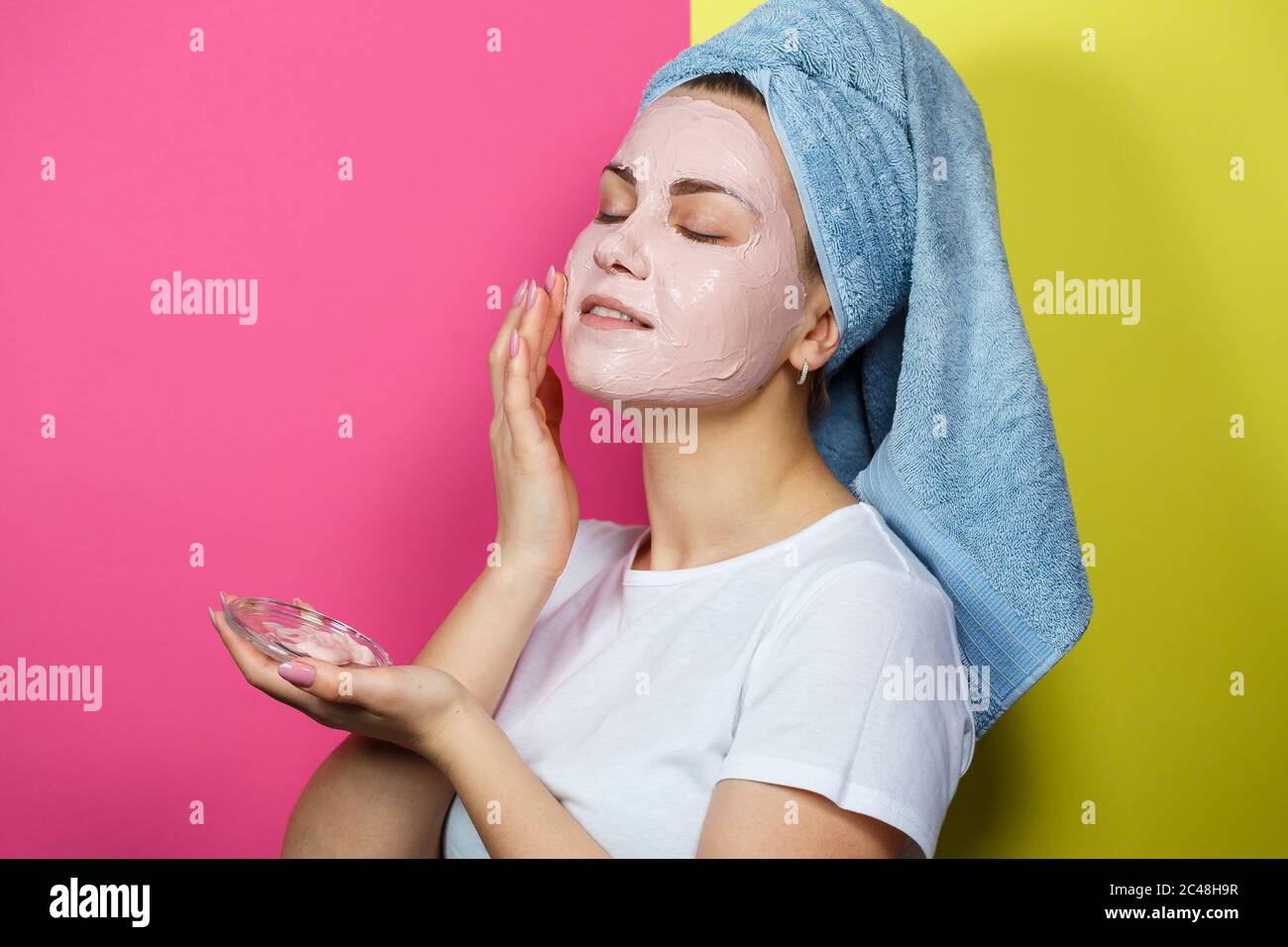 Portrait of a beautiful young girl who puts a refreshing mask on her ...