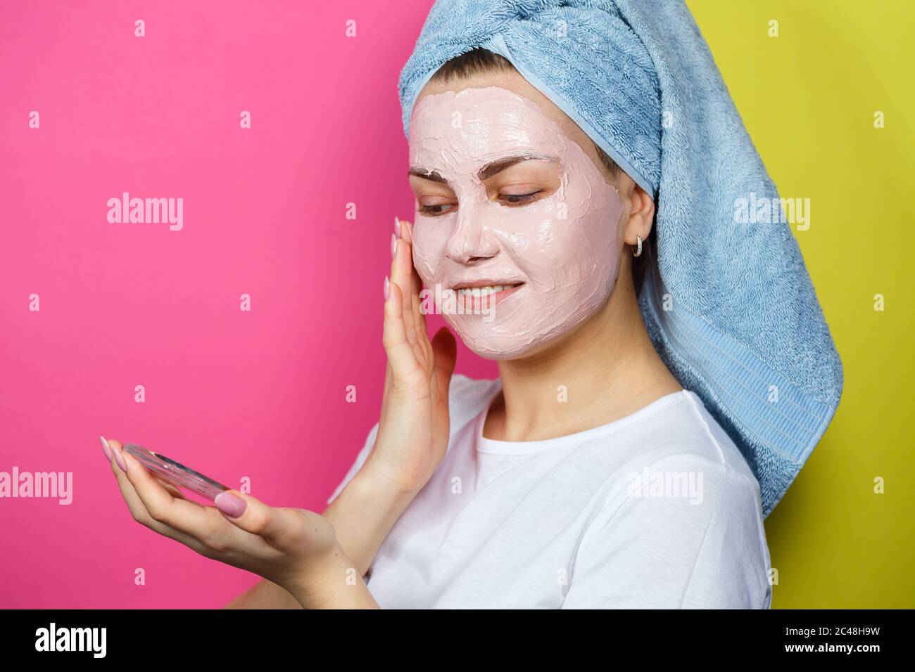 Portrait of a beautiful young girl who puts a refreshing mask on her ...