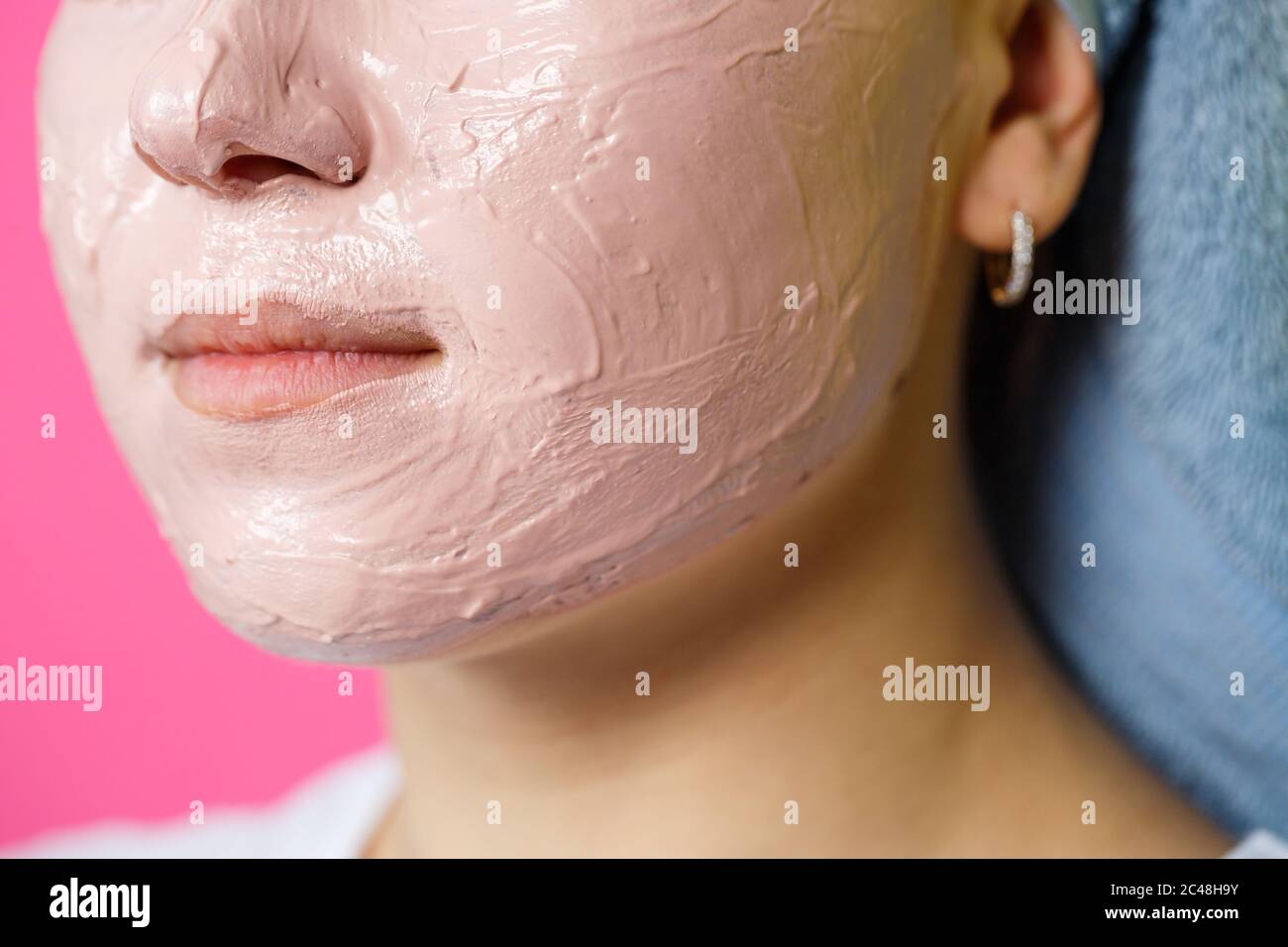 Portrait of a beautiful young girl who puts a refreshing mask on her ...