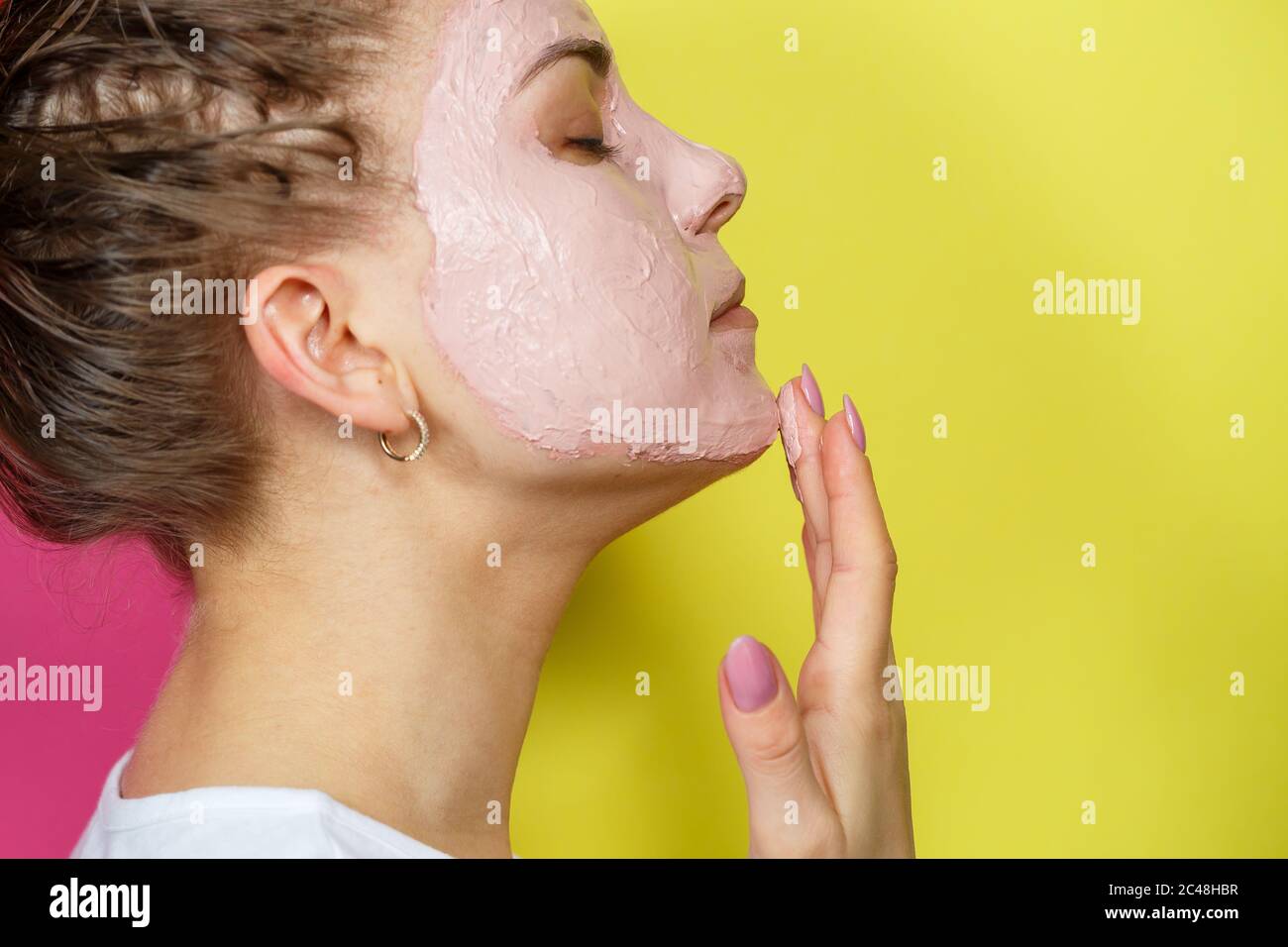 Portrait of a beautiful young girl who puts a refreshing mask on her ...
