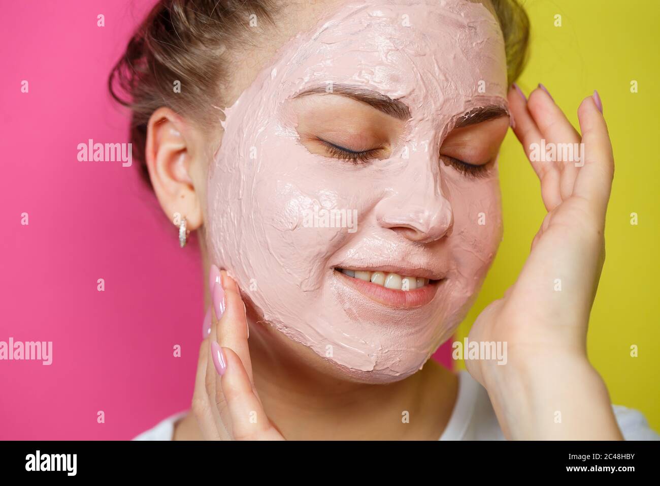 Portrait of a beautiful young girl who puts a refreshing mask on her ...