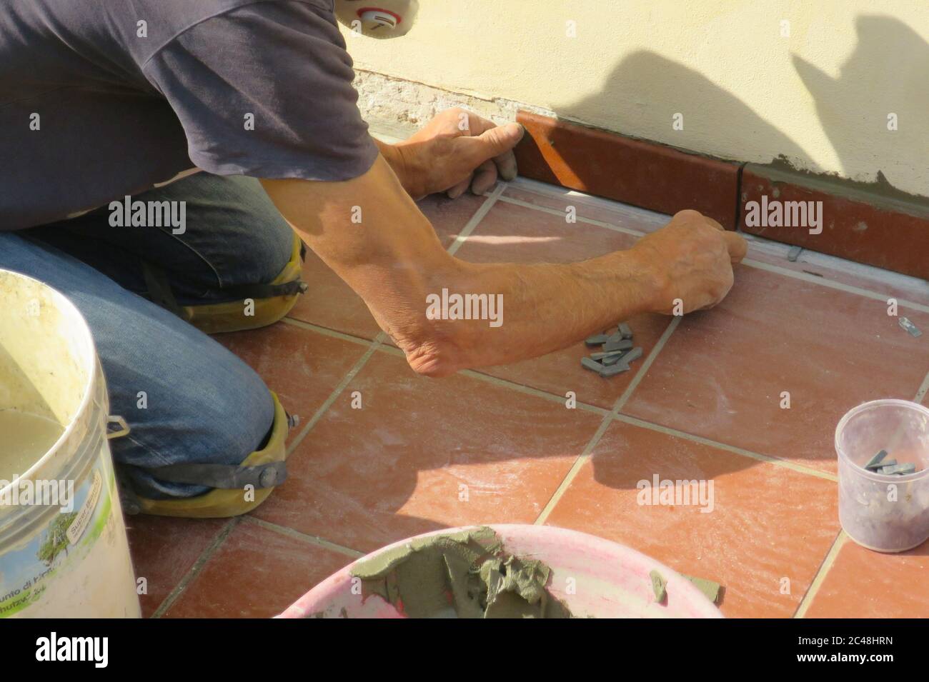High angle shot of a tiler laying ceramic tiles Stock Photo - Alamy