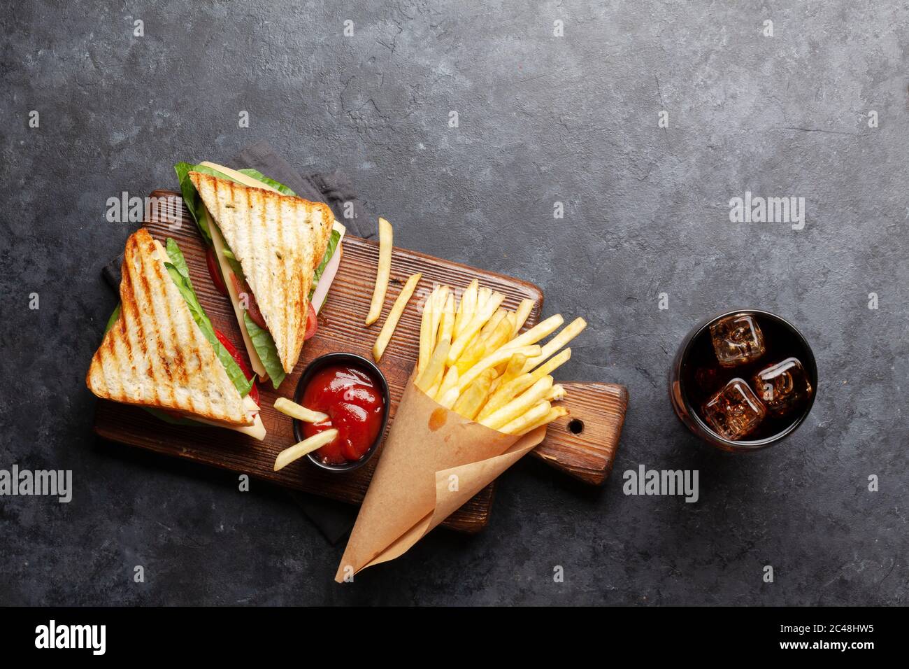 Club sandwich, potato fries chips and glass of cola drink with ice ...