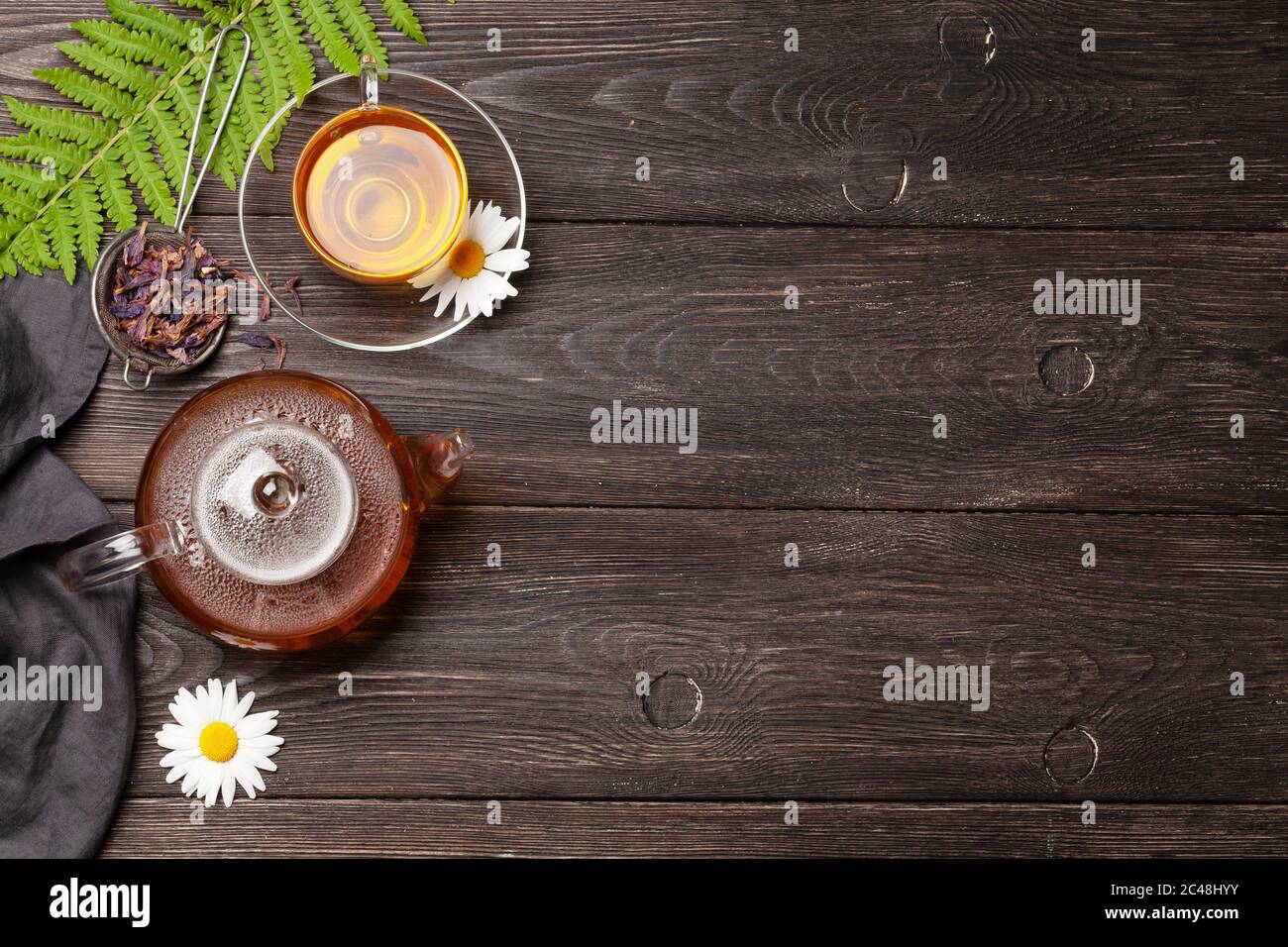 Herbal tea in teapot and cup on wooden table. Top view with copy space ...