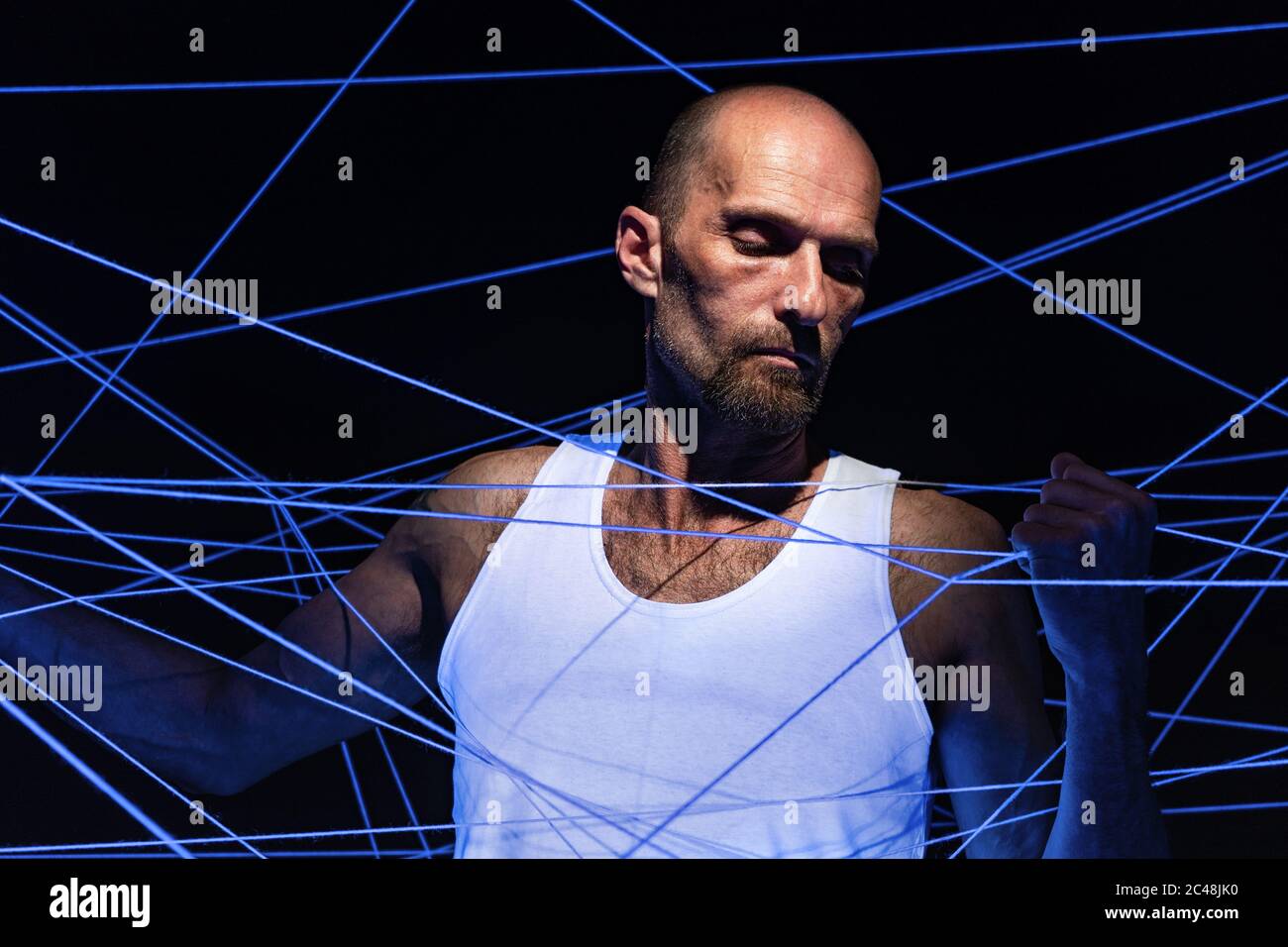 Photo of adult man tangled in white rope in ultraviolet Stock Photo - Alamy