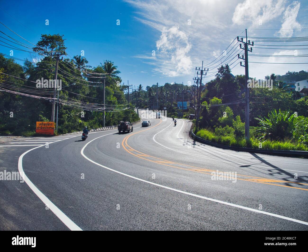 Five-lane highway with different vehicles under the blue sky and white ...