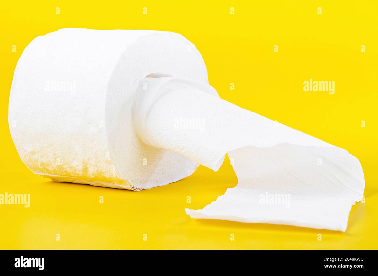 Tissue paper roll on the yellow background Stock Photo - Alamy