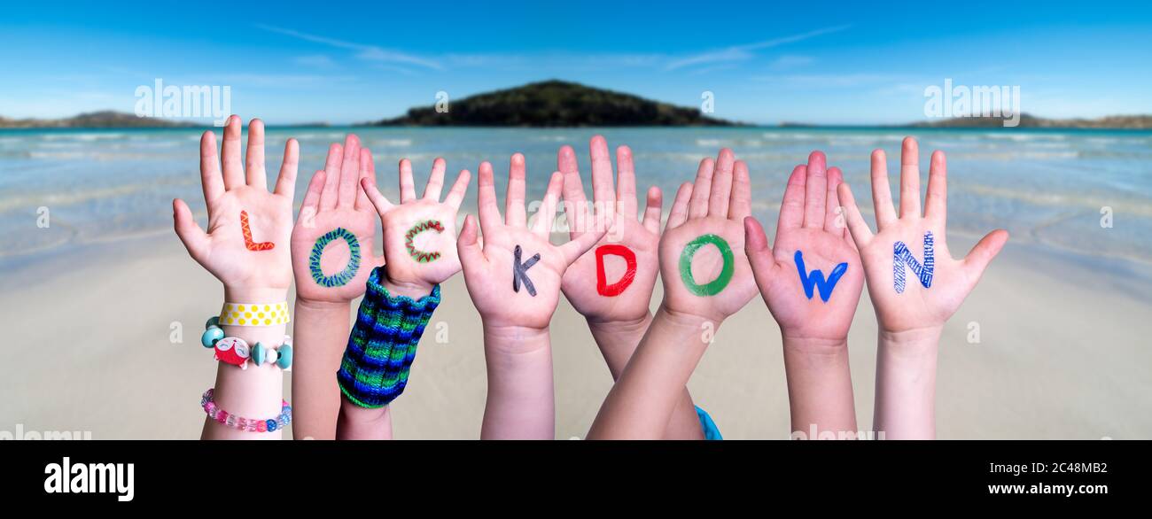 Kids Hands Holding Word Lockdown, Ocean Background Stock Photo - Alamy