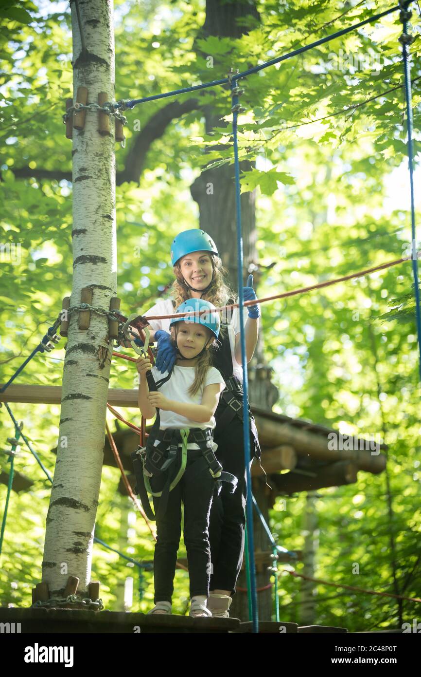 Rope adventure in the forest - smiling little girl and her mother ...