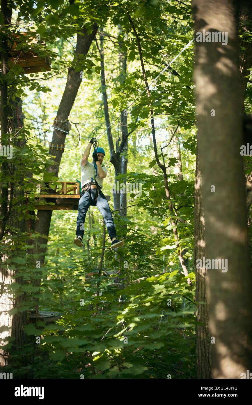A man having a rope adventure in the forest with full insurance ...