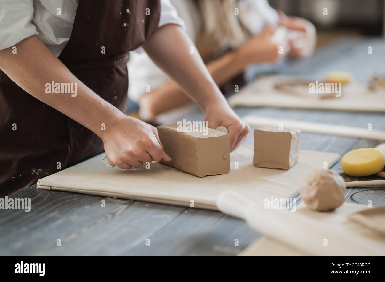 Woman cutting clay string tool hi-res stock photography and images - Alamy