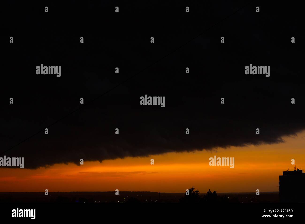 Black thunderclouds at sunset. Bright orange sunset and dark clouds ...