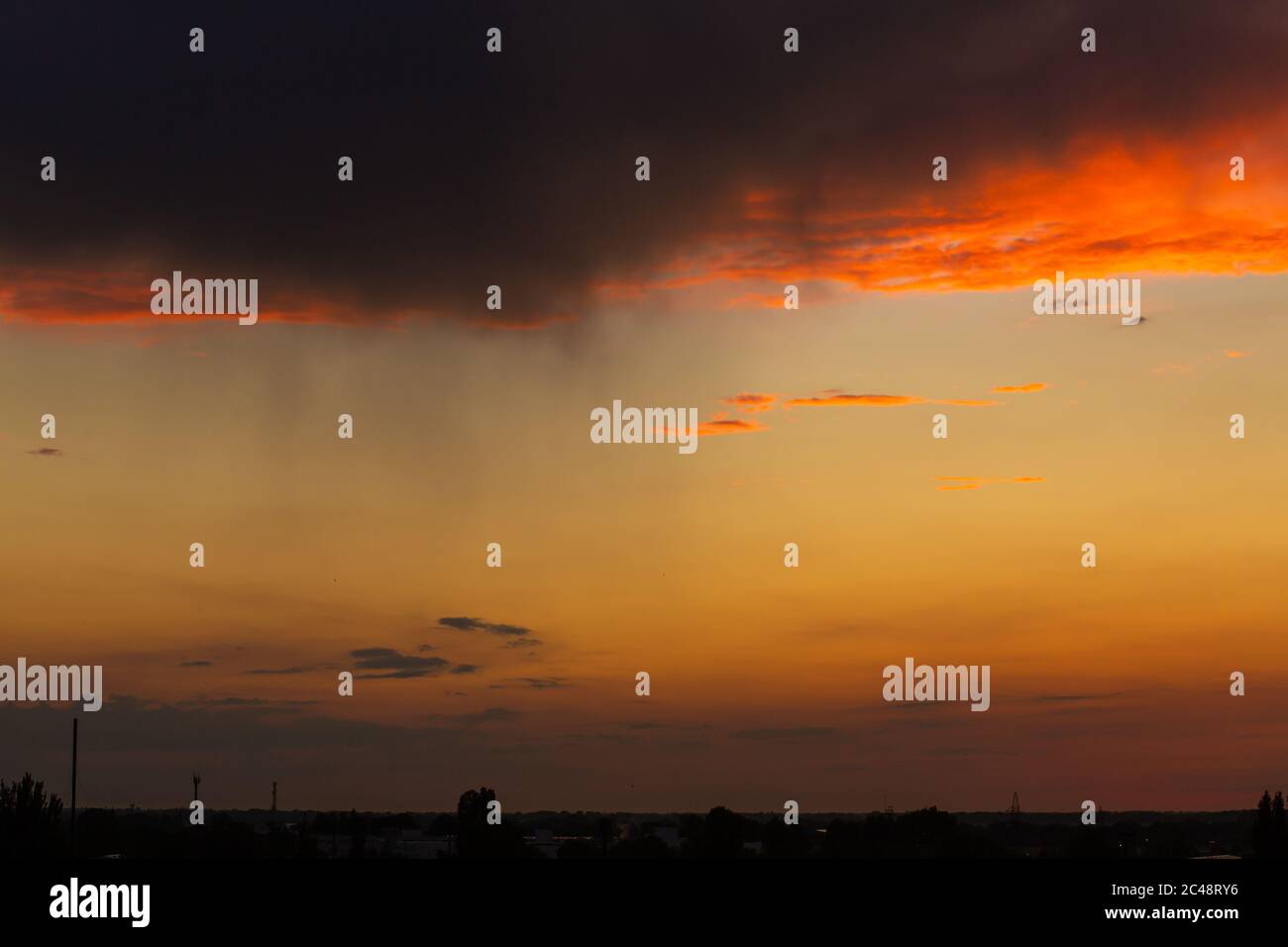 Black thunderclouds at sunset. Bright orange sunset and dark clouds ...