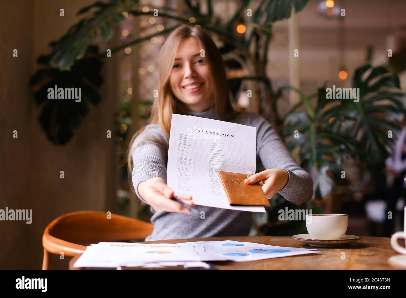 Focus on visa aplication and passport in caucasian girl hands at travel ...