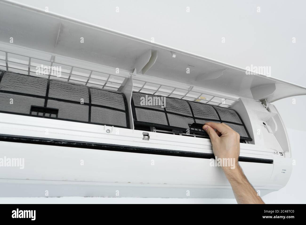 The guy cleans the filter of the home air conditioner from dust. Very ...