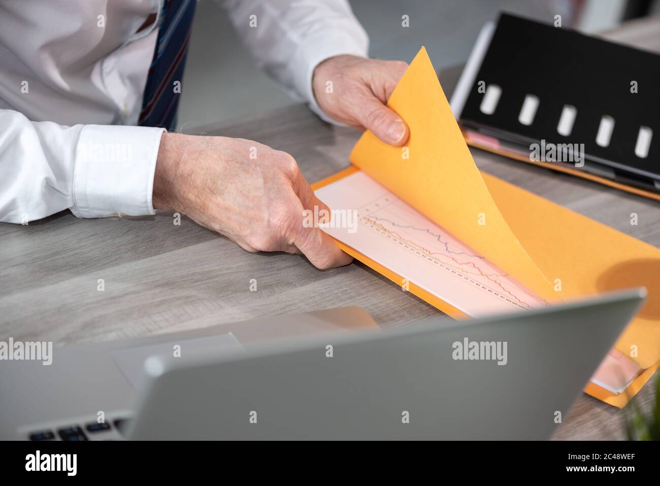Businessman opening folder with paper documents Stock Photo - Alamy