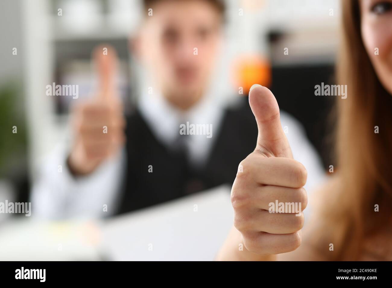Business colleagues giving thumbs up at work Stock Photo - Alamy