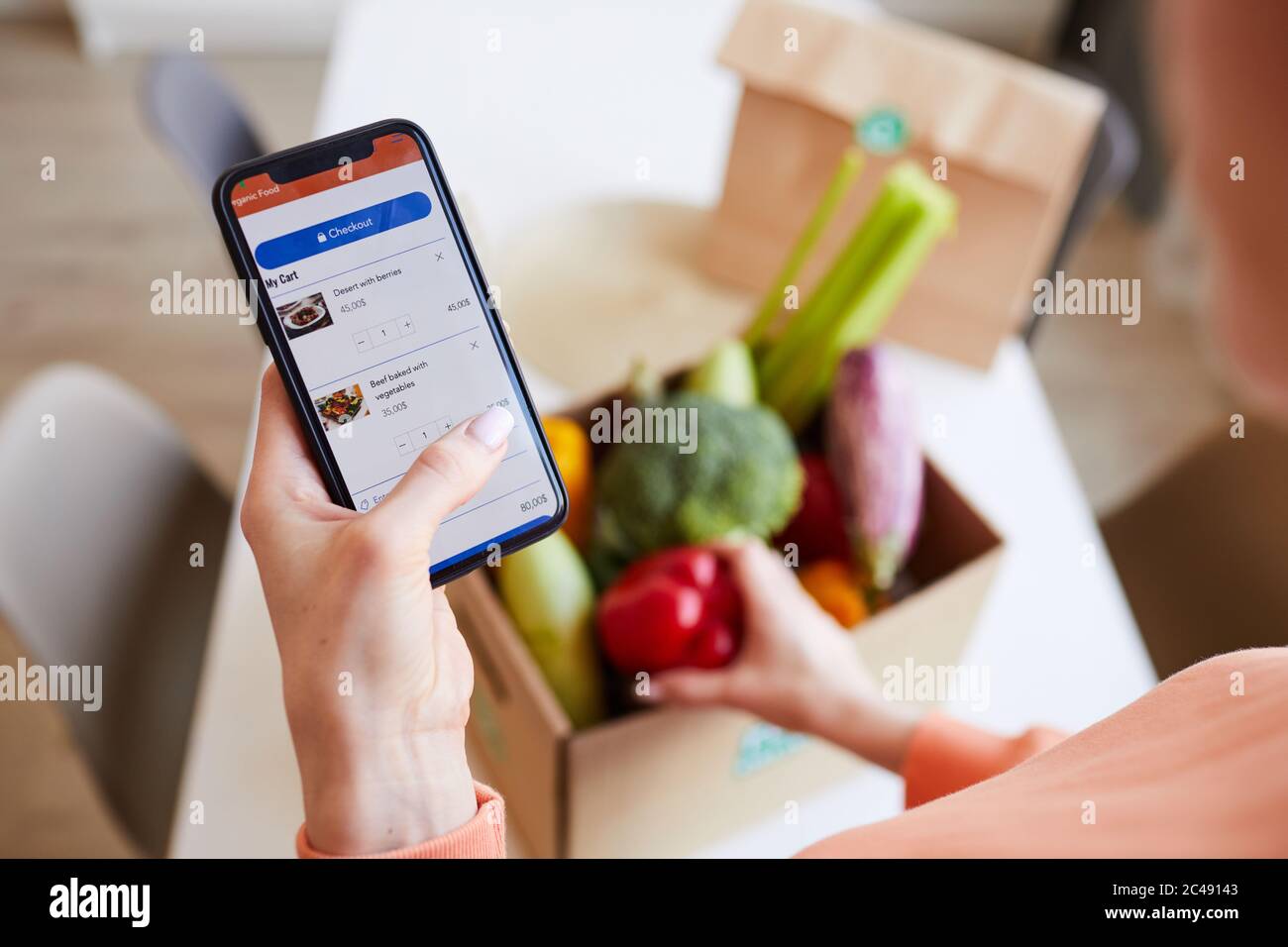 Close-up of woman ordering food online from her mobile phone at home ...