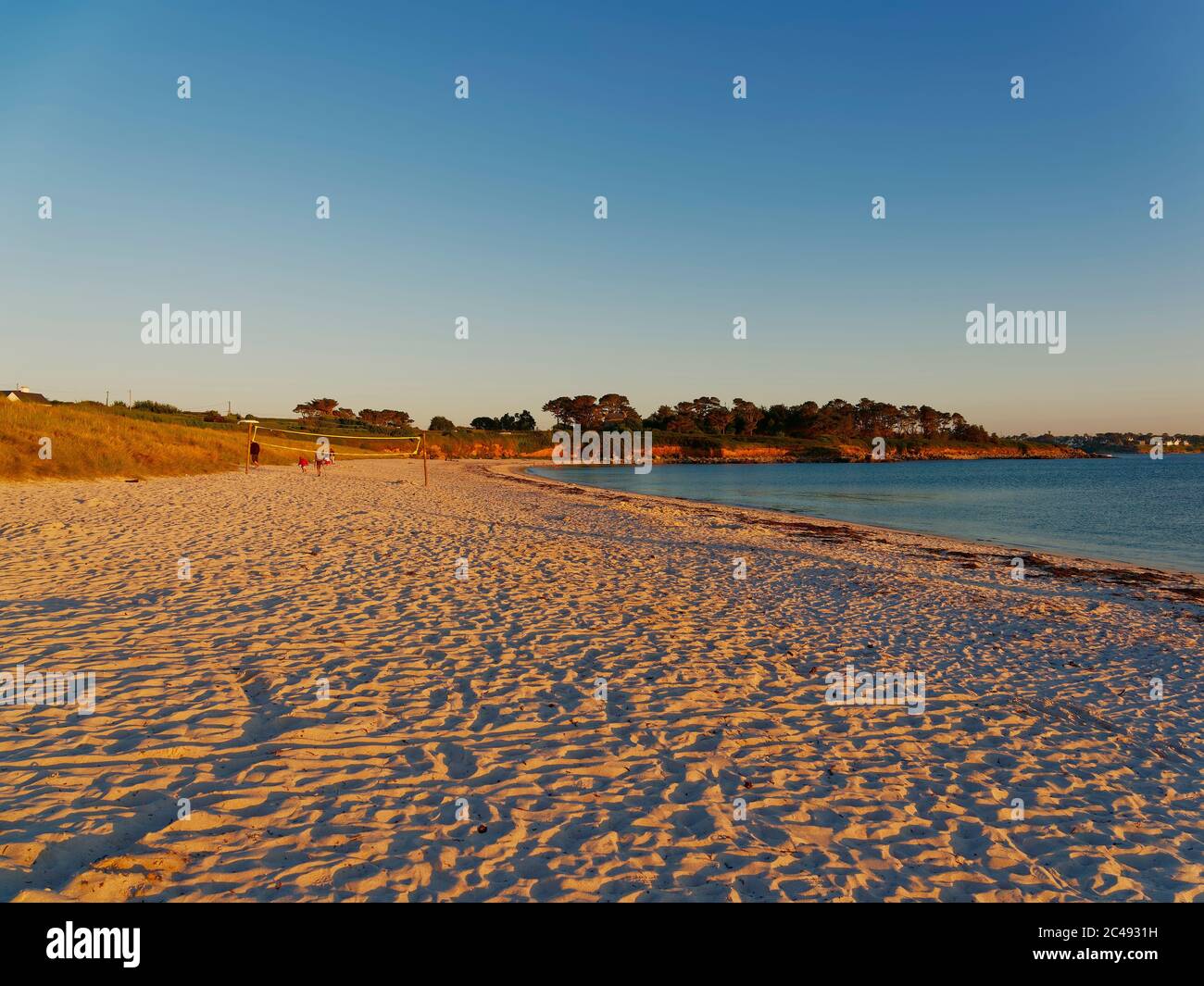 Sunset on a long, curved beach at Landeda, Brittany. In the distance ...