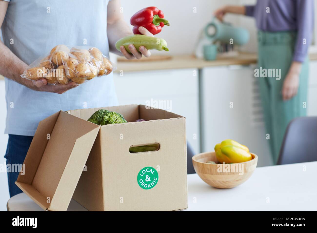Close-up of young man taking food out of the box in the domestic ...