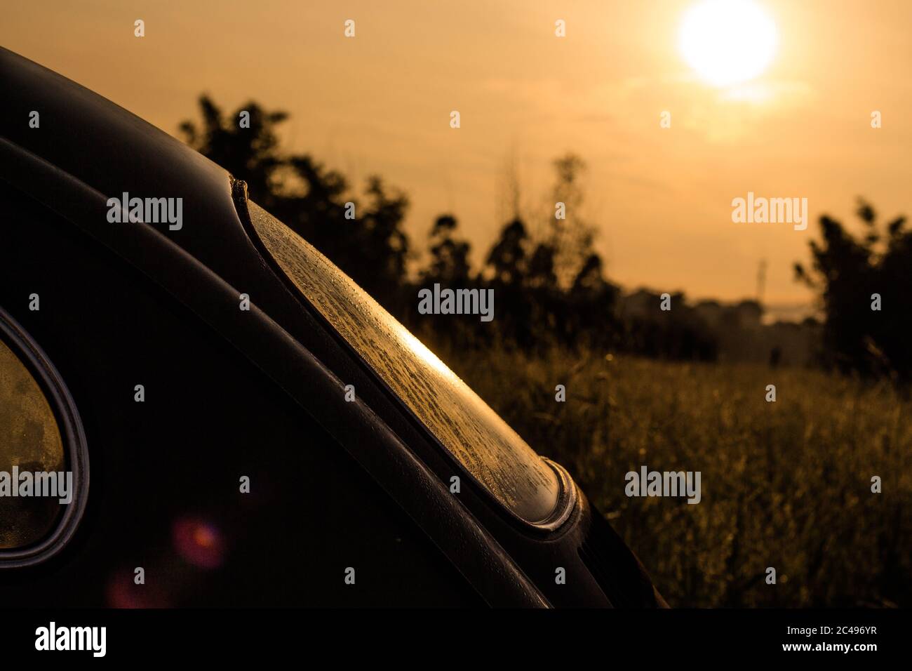 Shot of Volkswagen beetle car's back portion with a sunset background ...