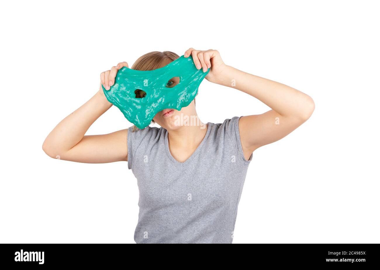 Funny girl holding a slime in front of her face and looking through its ...