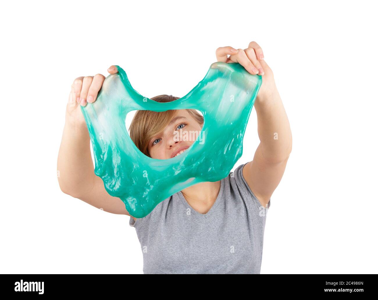 Funny girl holding a slime and looking through its hole. Focused on the ...