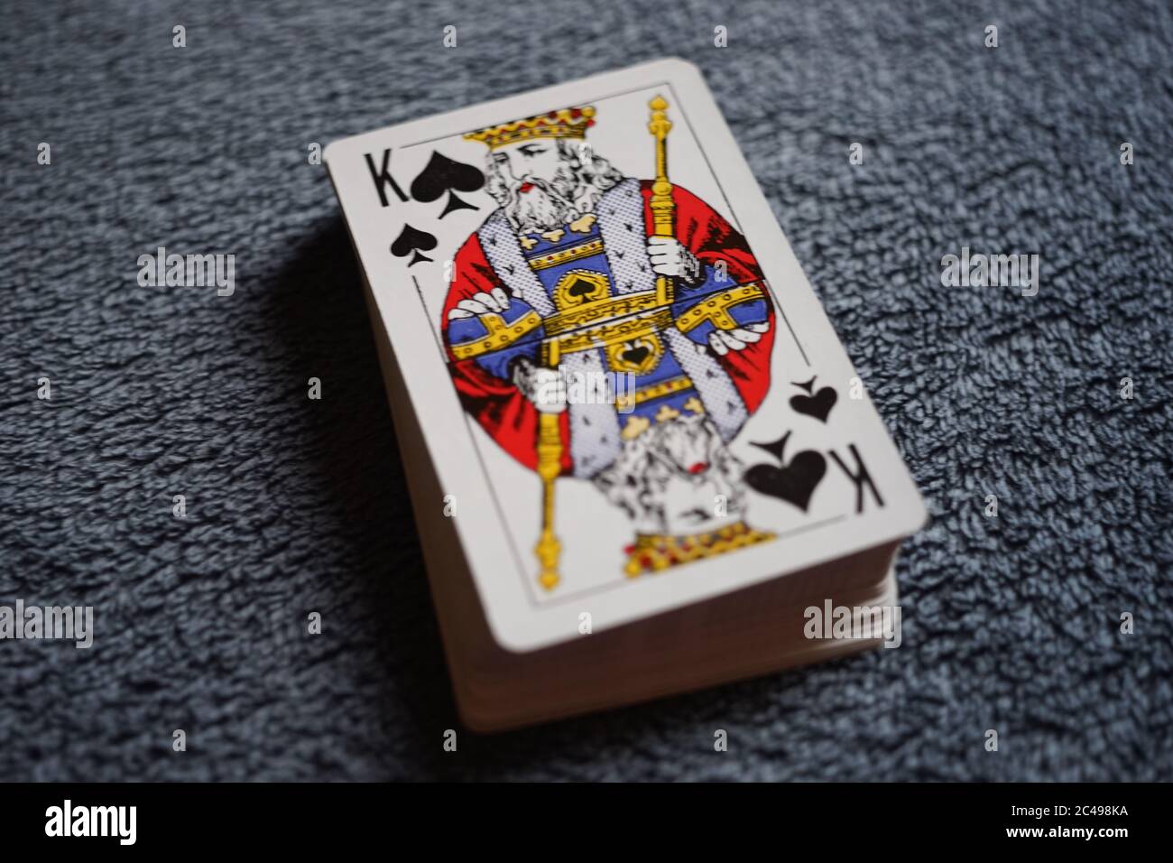 When new playing cards on a gray plush table, the king of spades is the ...