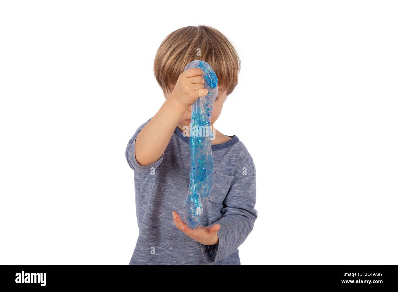 Cute small boy playing with a blue glitter slime. Isolated on white ...