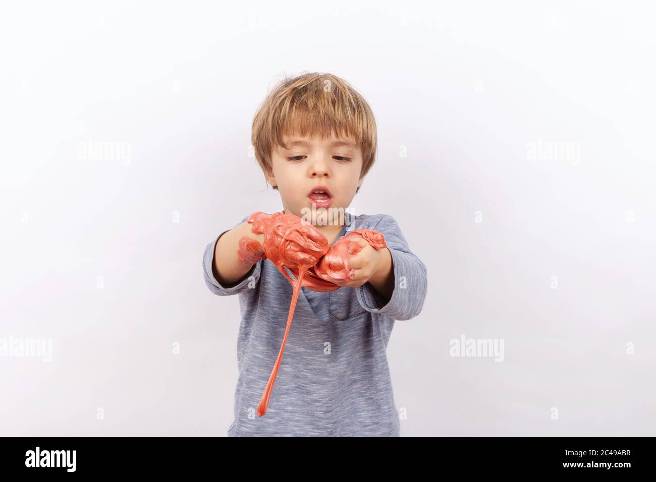 Funny small boy playing with slime Stock Photo - Alamy