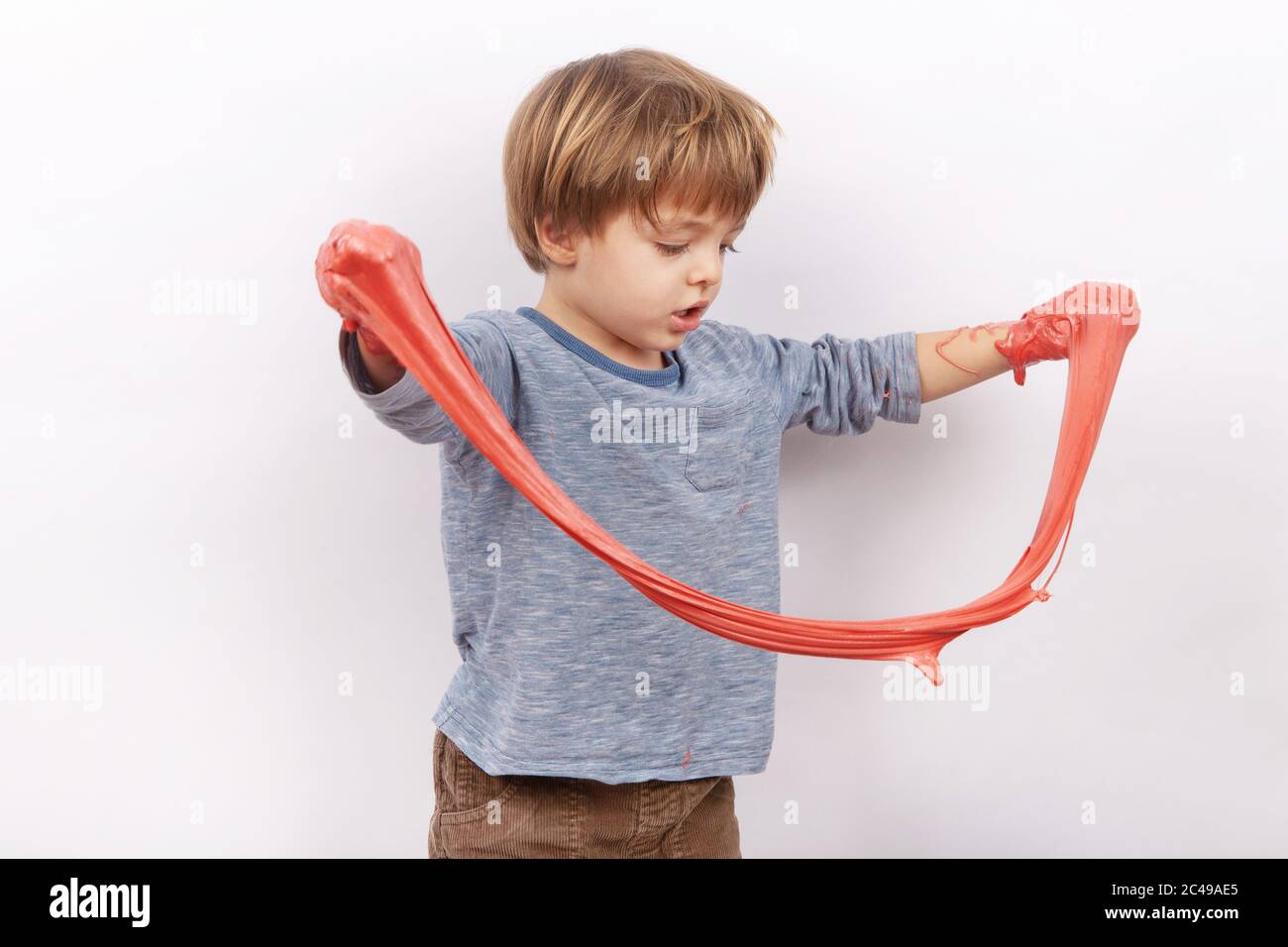 Adorable small boy playing with slime Stock Photo - Alamy