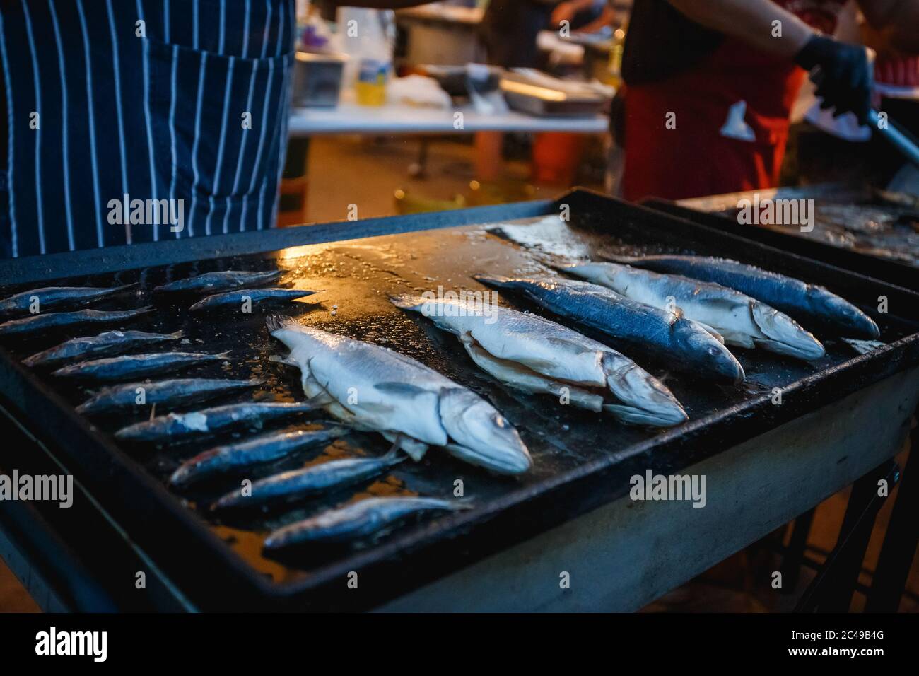 Shot of a man grilling fishes Stock Photo - Alamy