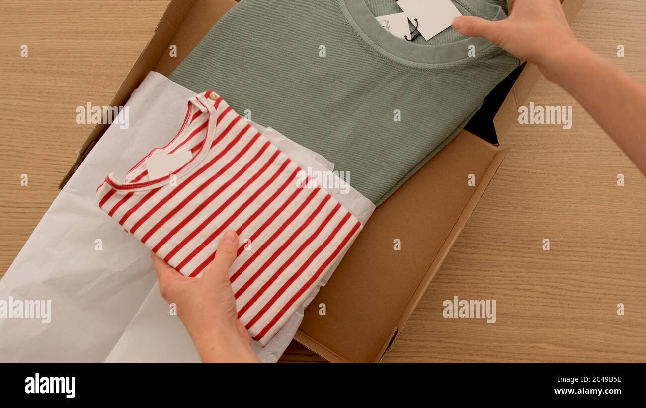 Unpacking a parcel of clothes Stock Photo - Alamy