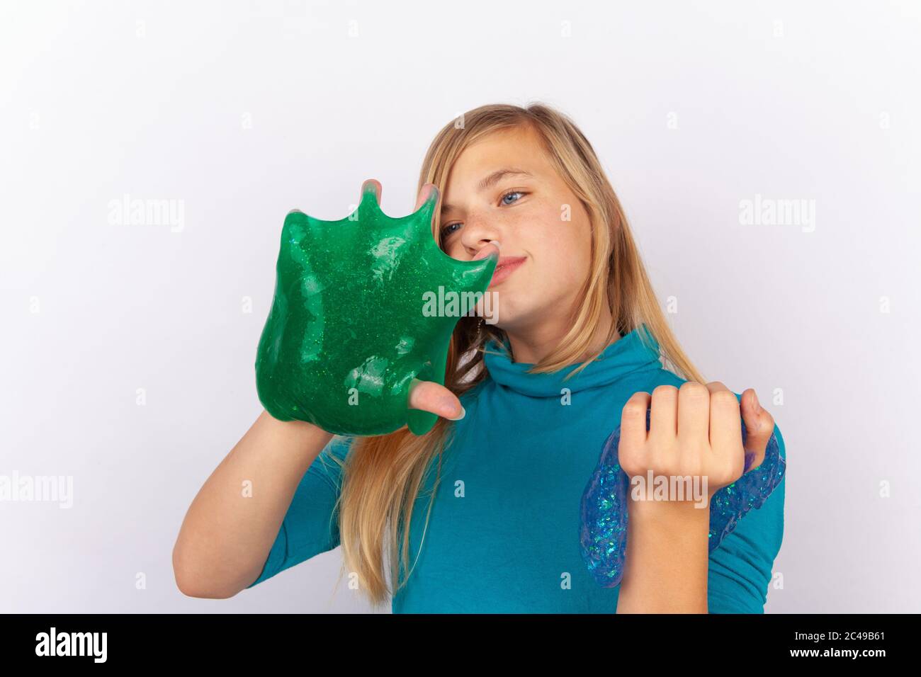 Beautiful young girl playing with green and blue slimes Stock Photo - Alamy