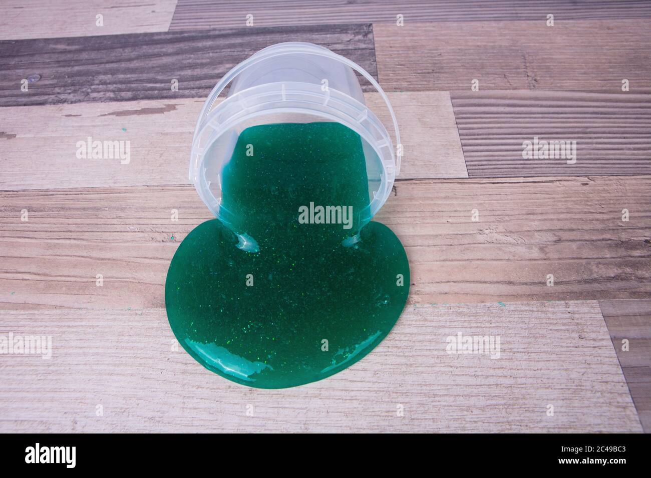 Green slime from a plastic bucket on a wooden table Stock Photo - Alamy