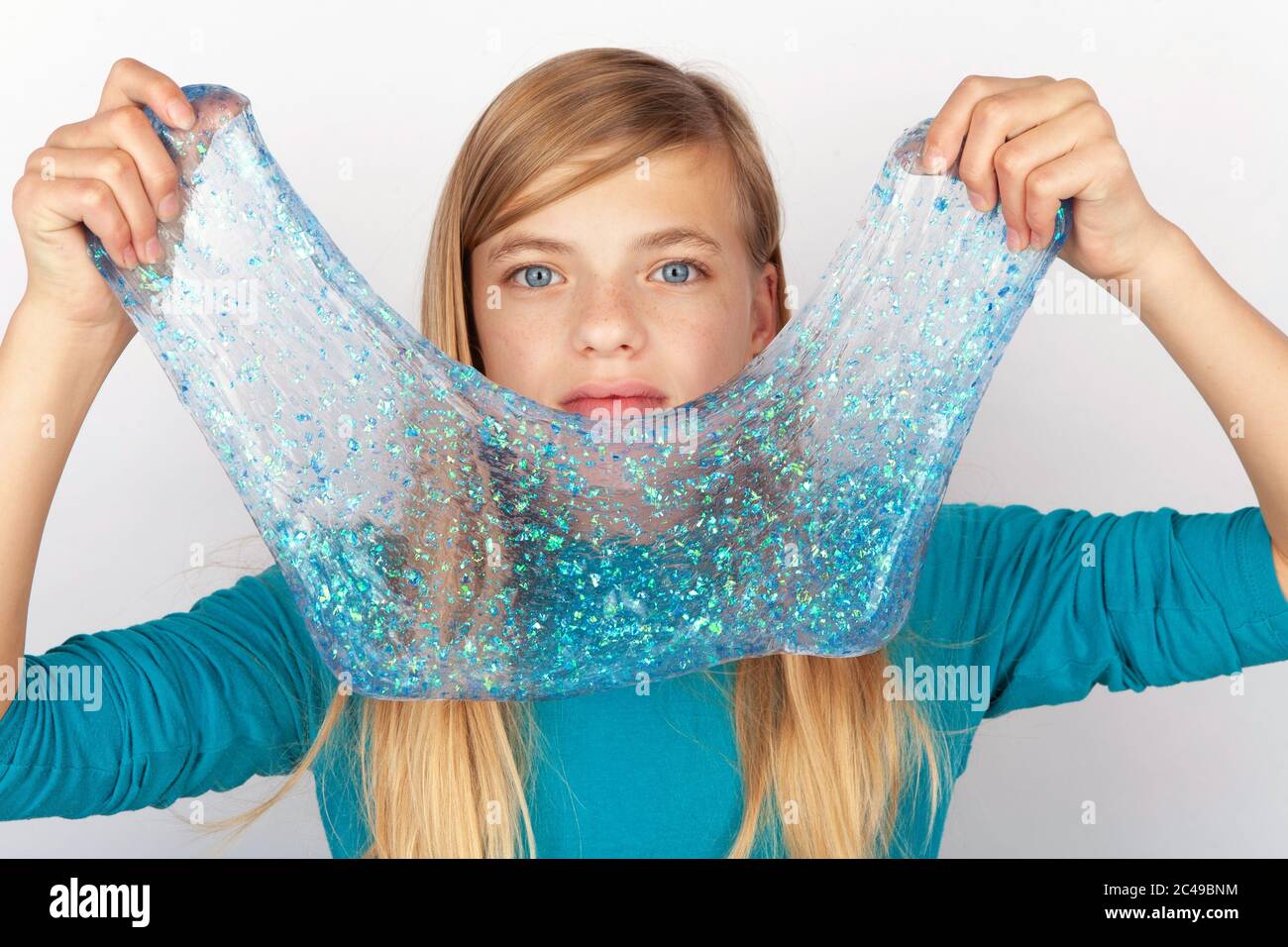 Beautiful young girl holding a glitter slime in front of her face Stock ...