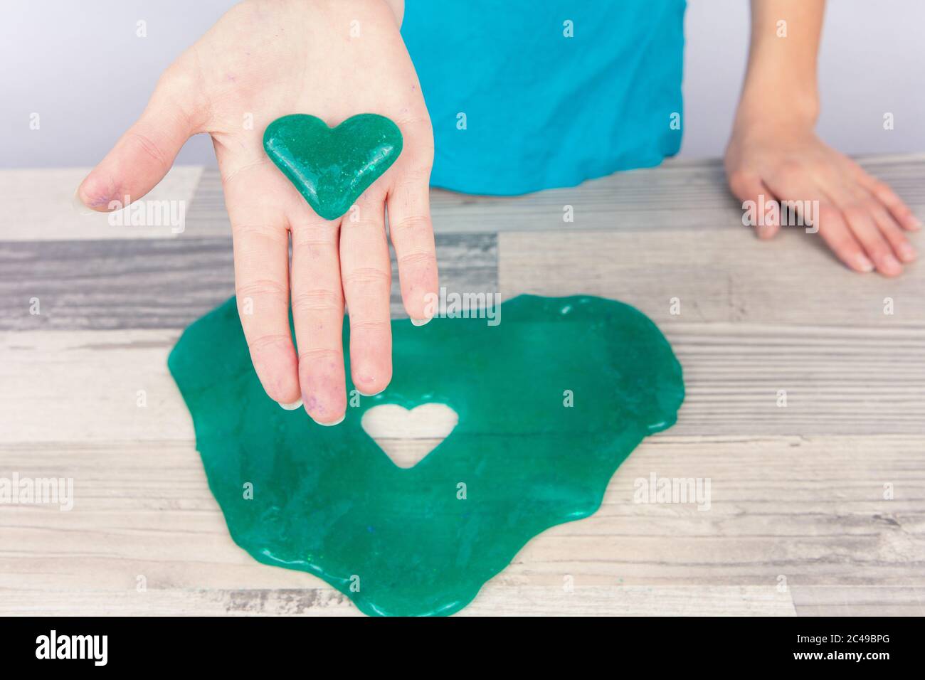 Girl created a heart shape slime with a cookie cutter and showing it on ...