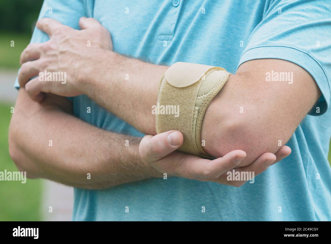 Man wearing elbow brace to reduce pain Stock Photo - Alamy