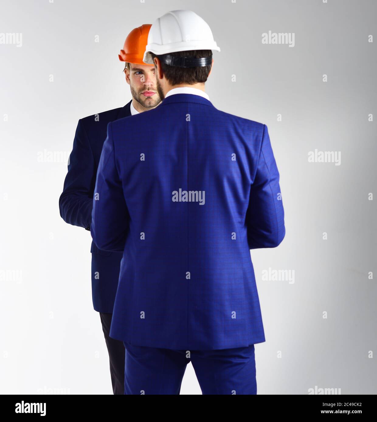 Entrepreneur and engineer back view. Engineers with serious faces ...