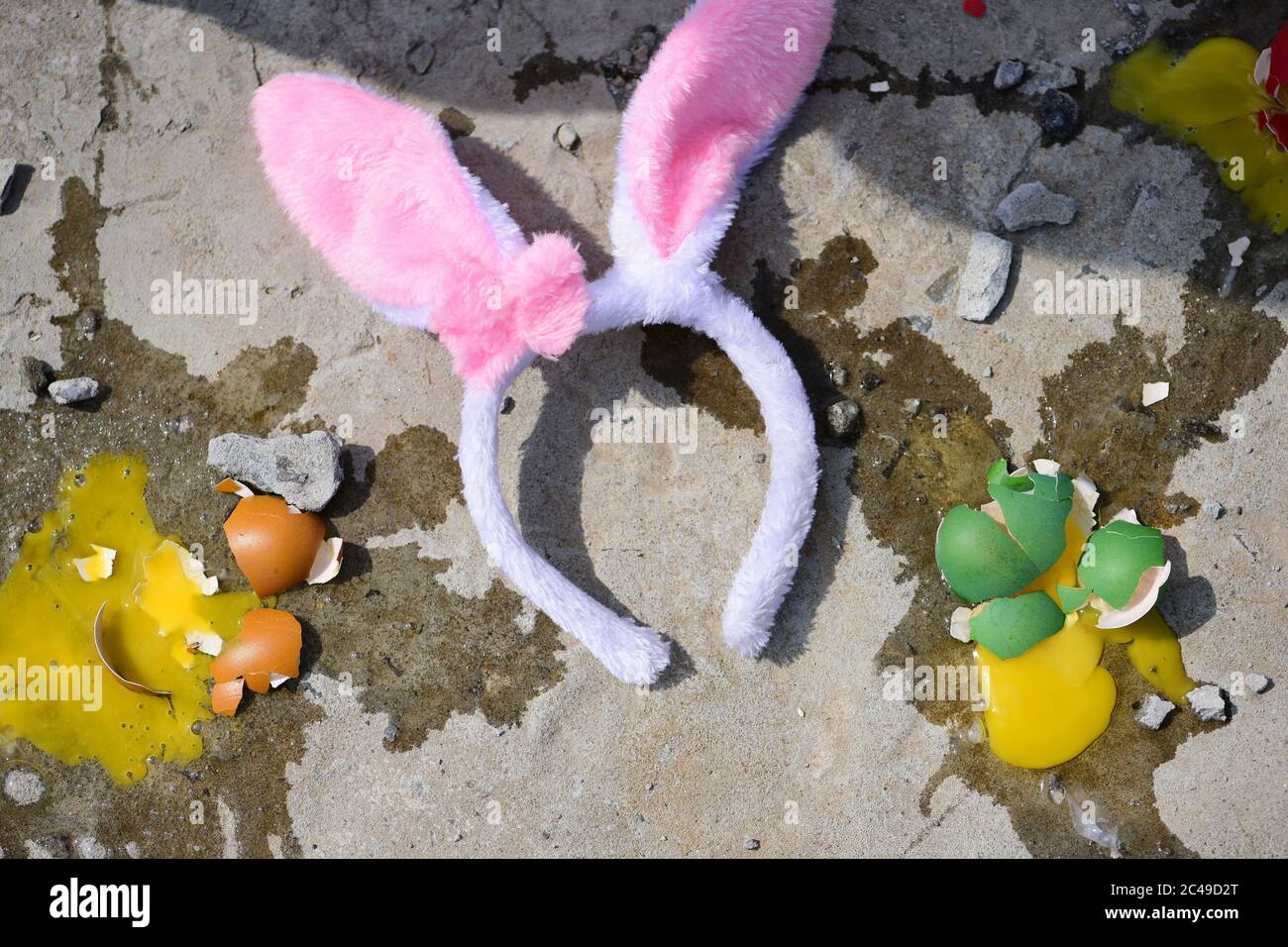 Easter eggs broken and bunny ears headband on asphalt background. Green ...