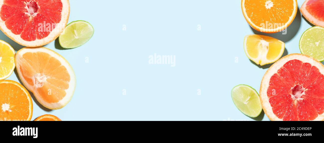 Banner with borders made of citrus fruits on blue background. Top view ...