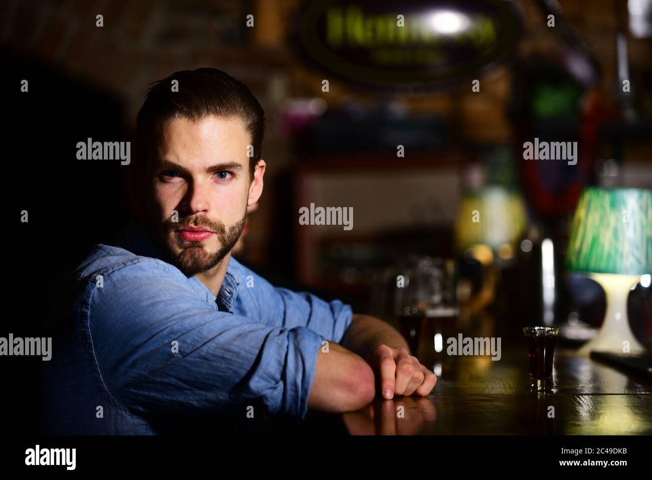 Bearded man drink alcohol on blurred bar background. Friday night ...
