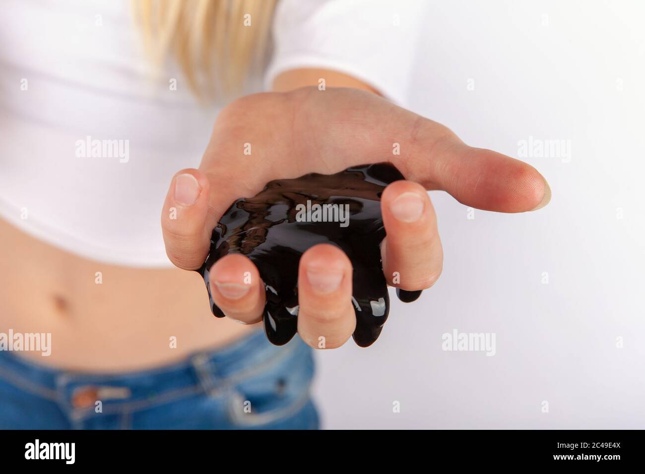Young girl's hand holding black slime Stock Photo - Alamy