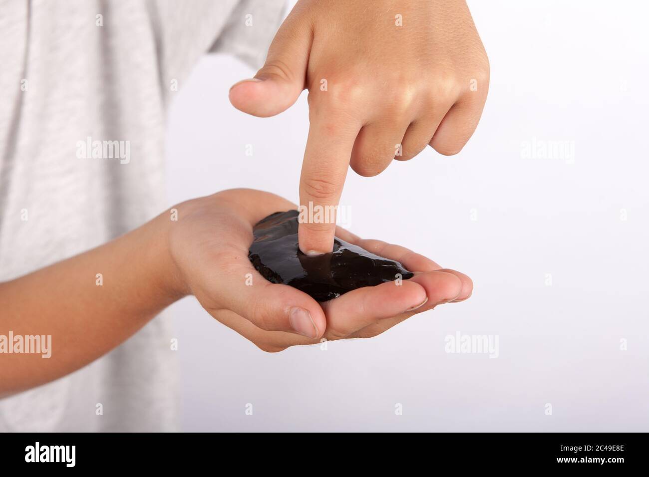Young boy holding a black slime in his hand Stock Photo - Alamy