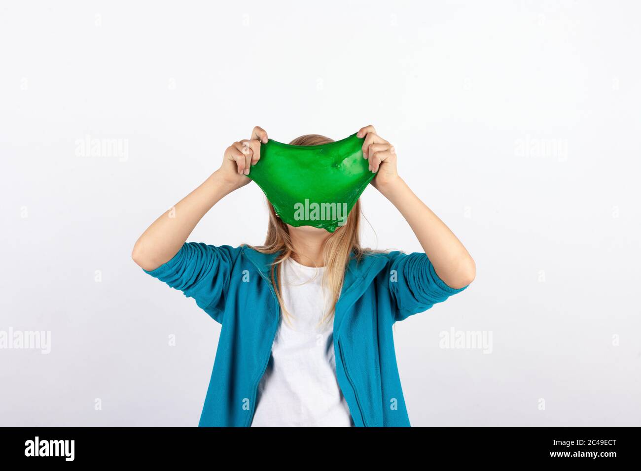 Funny girl holding green slime in front of her face Stock Photo - Alamy