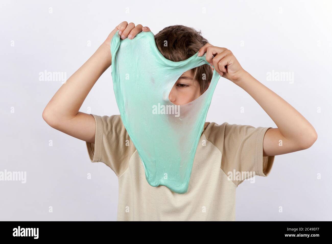 Boy holding a slime in front of his face and looking through its hole ...