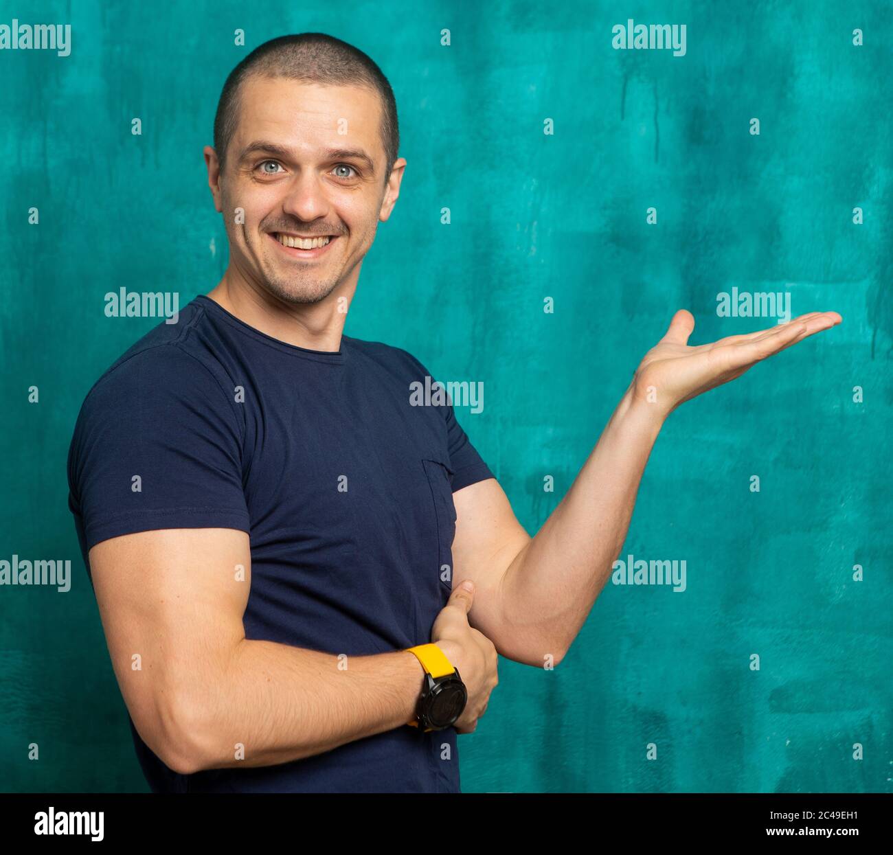 Portrait of smiling handsome man show something by hand Stock Photo - Alamy